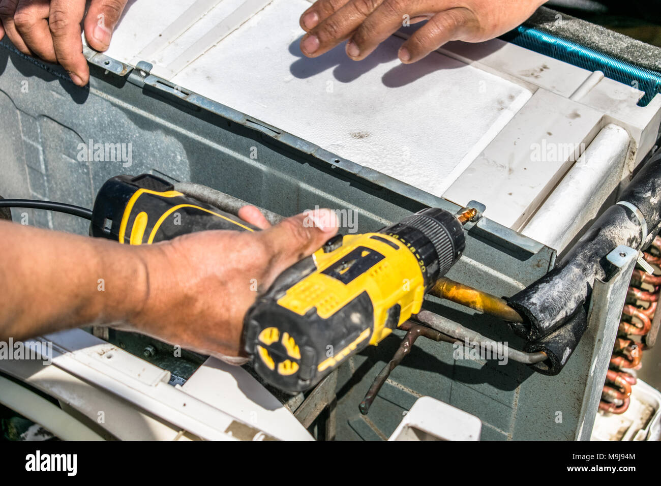 a professional electrician man is fixing the screw by auto screw driver ...