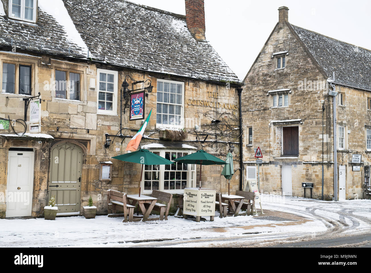 The Cotswolds Arms on the high street in the winter snow. Burford ...