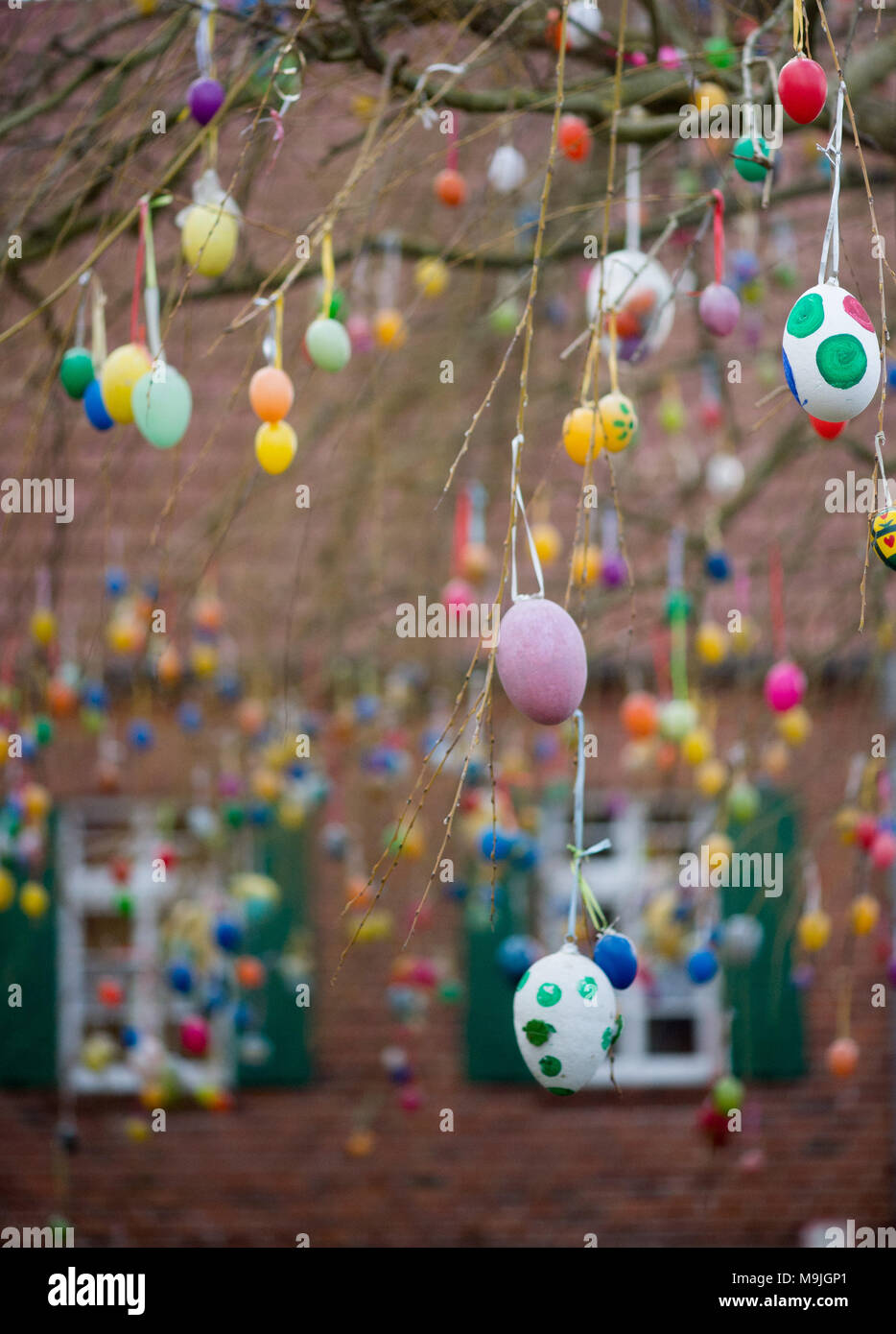 20 March 2018, Germany, Wulkau: Easter eggs hanging from the branches ...