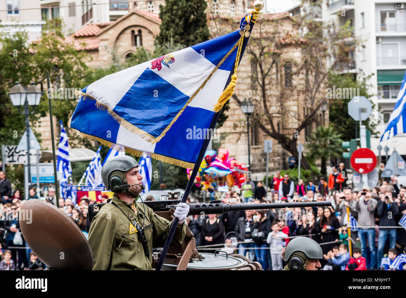 A soldier with a Greek flag is seen on a tank during the parade. A ...