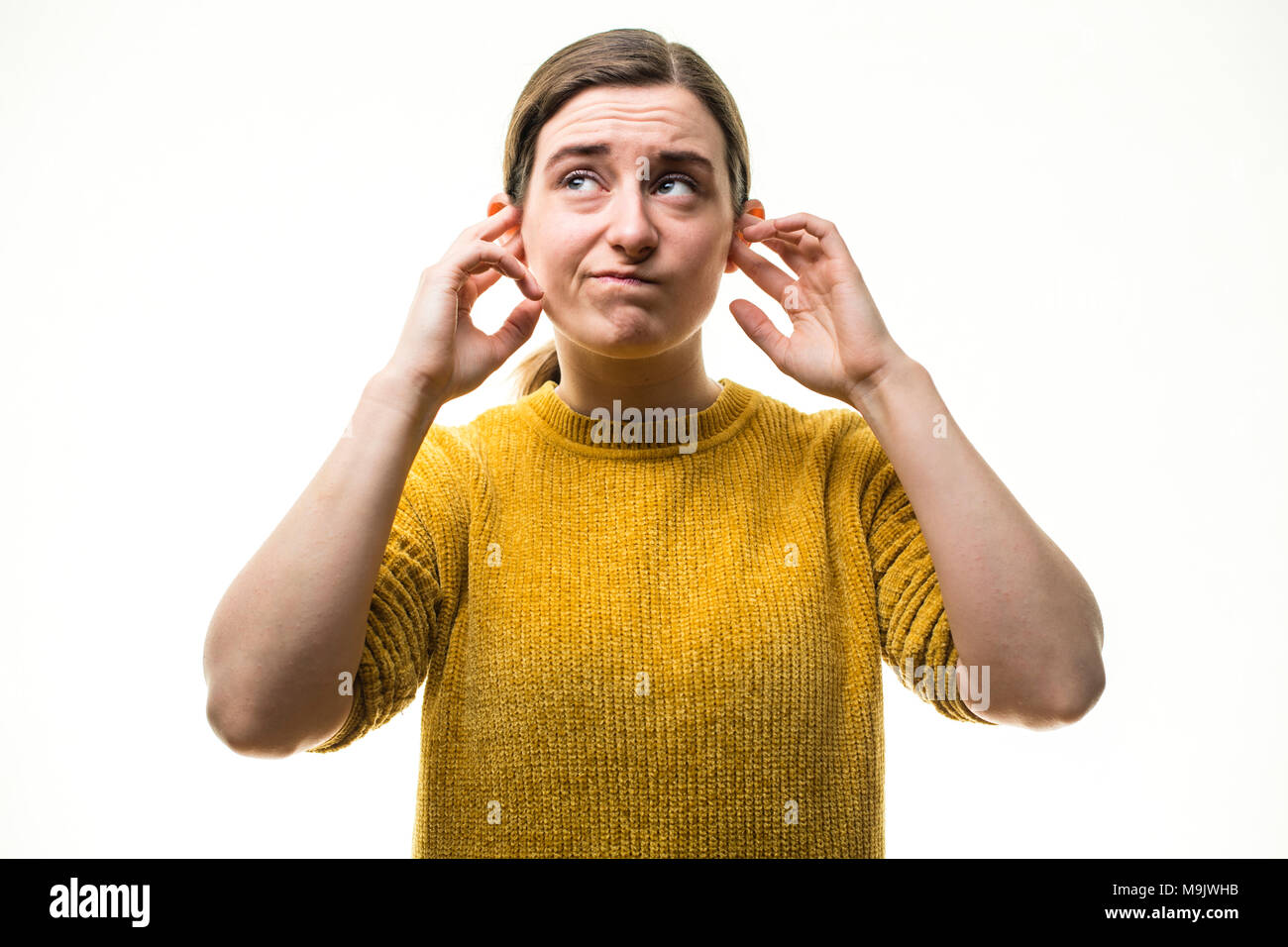 Noise pollution: A young Caucasian woman girl with her fingers in her ...