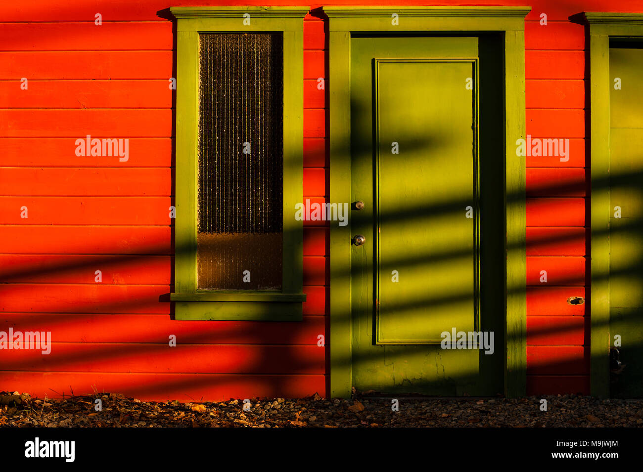 Sunlight striking side of colorful wood wall with shadows creating ...
