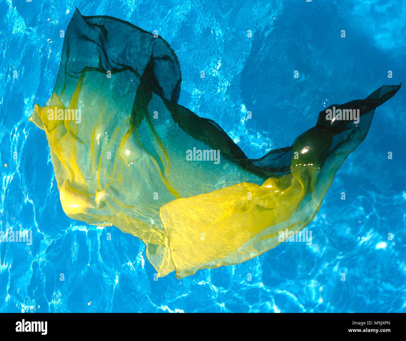 Yellow and black fabric floating in pool Stock Photo - Alamy