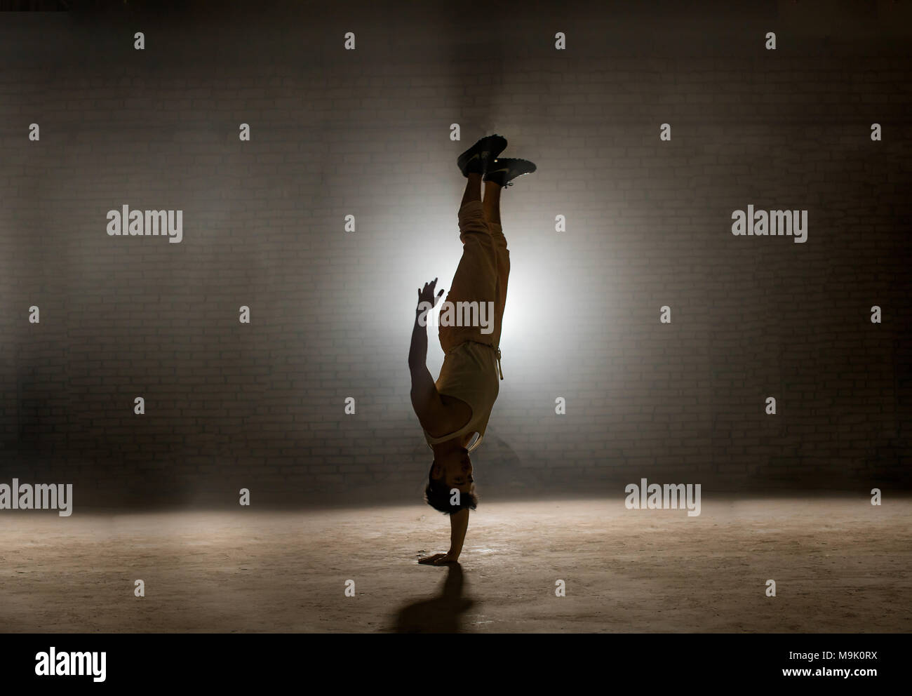 young sporty man doing one arm handstand outside.straight back ...