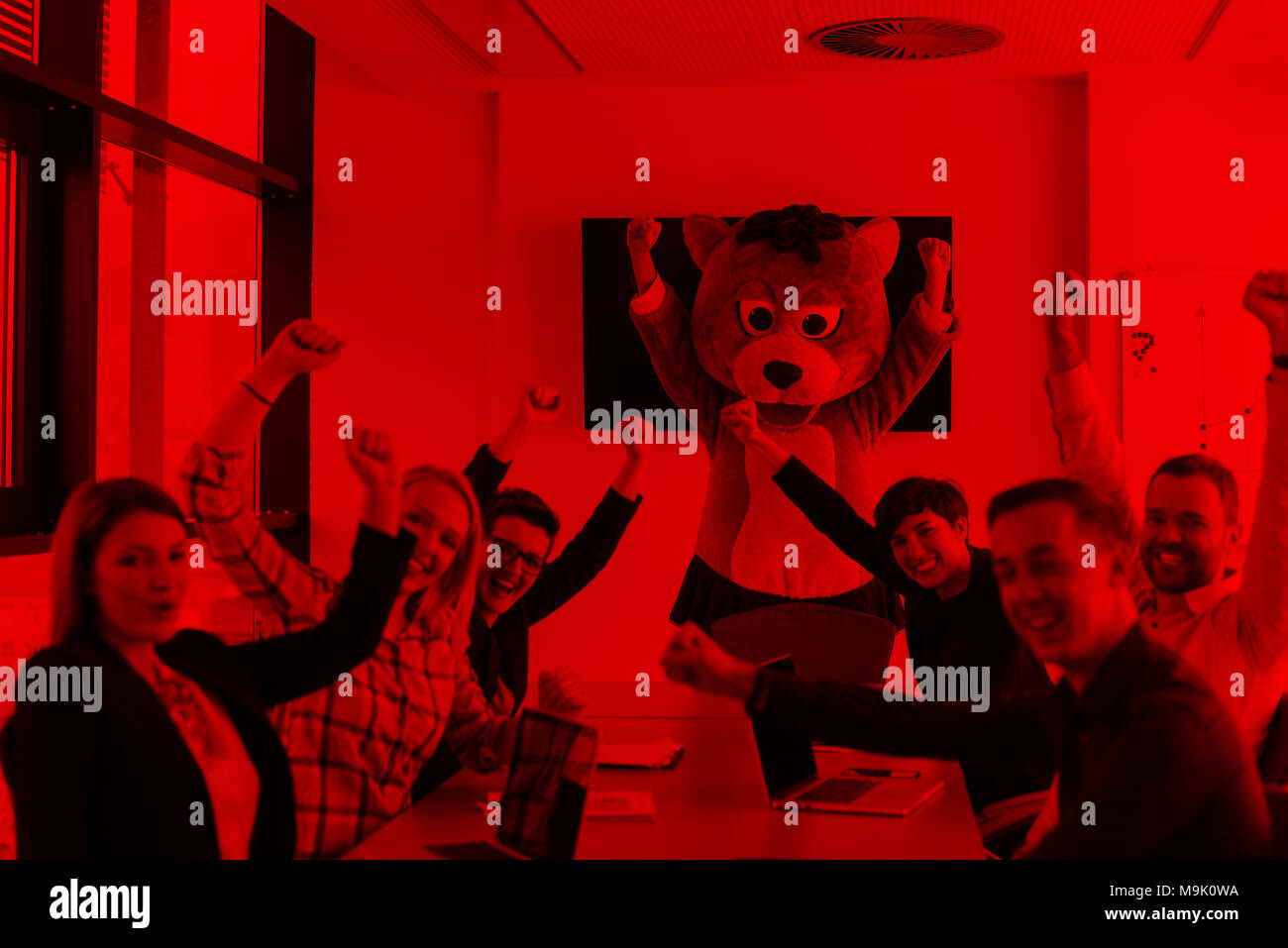 Boss dresed as teddy bear having fun with bussines people in modern ...