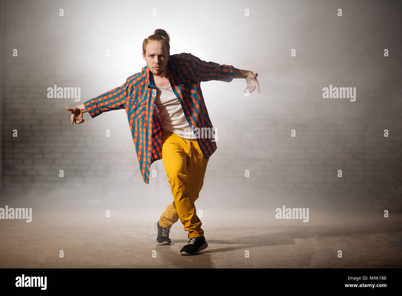 young ginger boy showing his dancing talent to people. looking at the ...