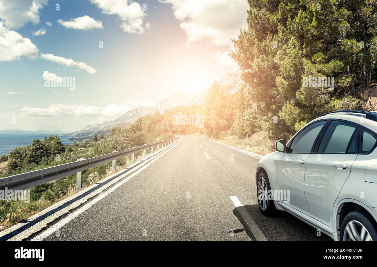 A white car rushing along a high-speed highway in the sun Stock Photo ...