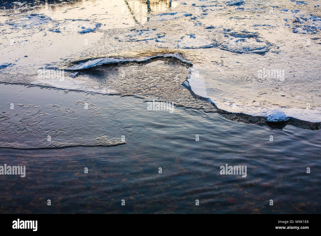 Frozen river surface covered with melting ice Stock Photo - Alamy