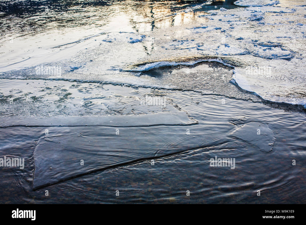 Frozen river surface covered with melting ice Stock Photo - Alamy