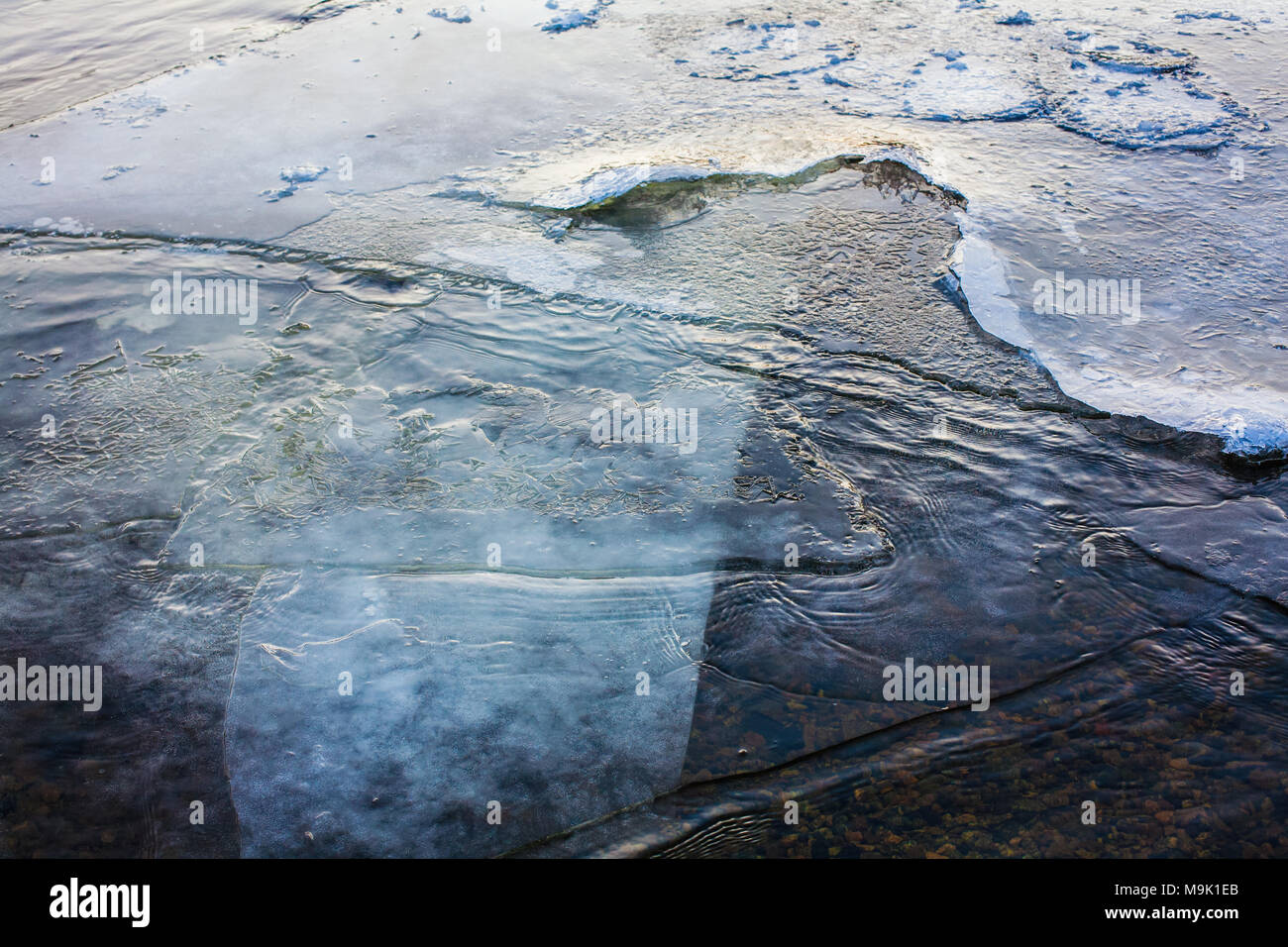 Frozen river surface covered with melting ice Stock Photo - Alamy
