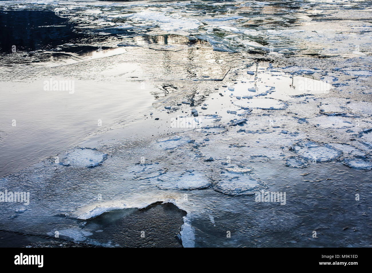 Frozen river surface covered with melting ice Stock Photo - Alamy