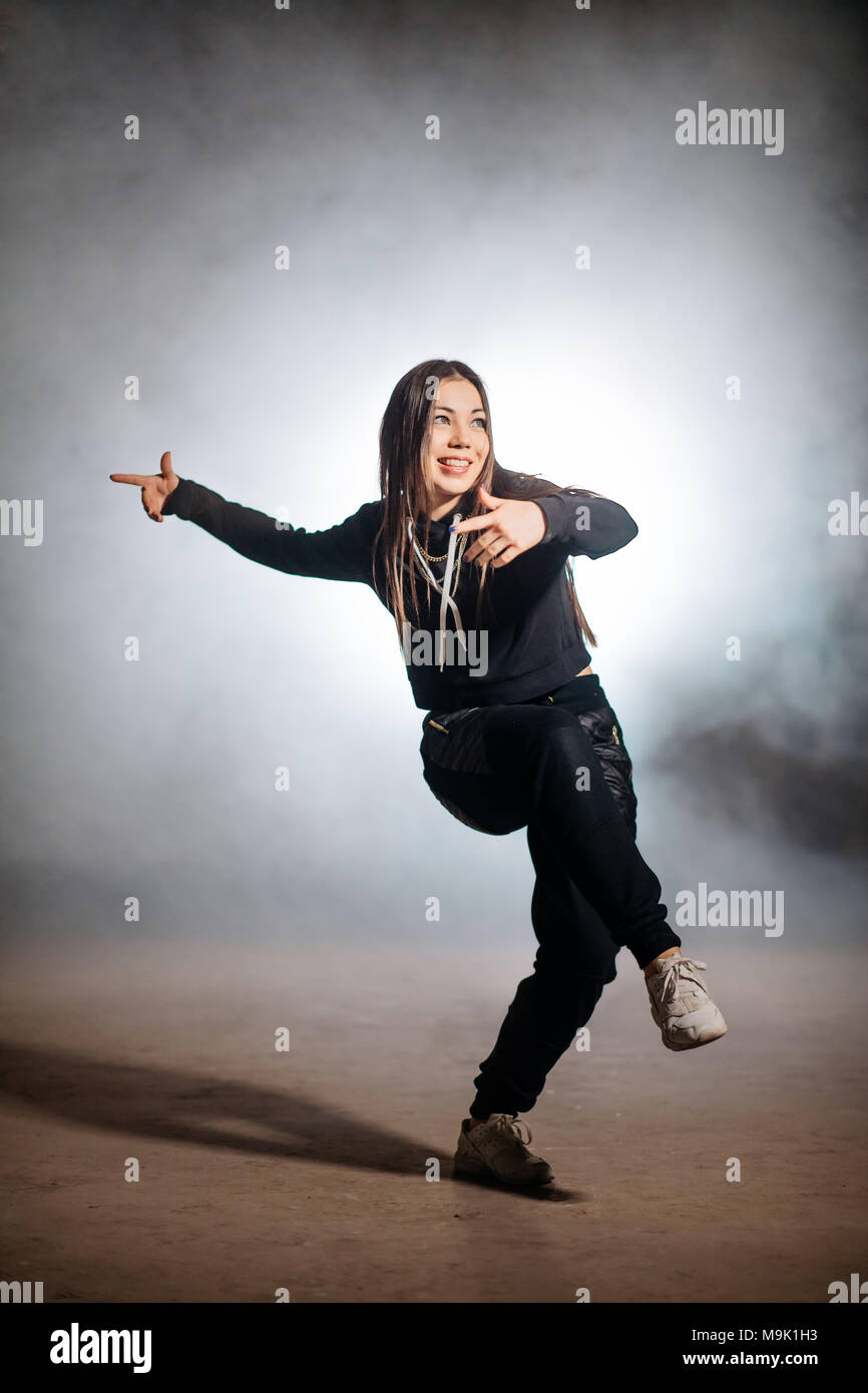 smiling female in sporty clothers is demonstrating dance step. trying a ...