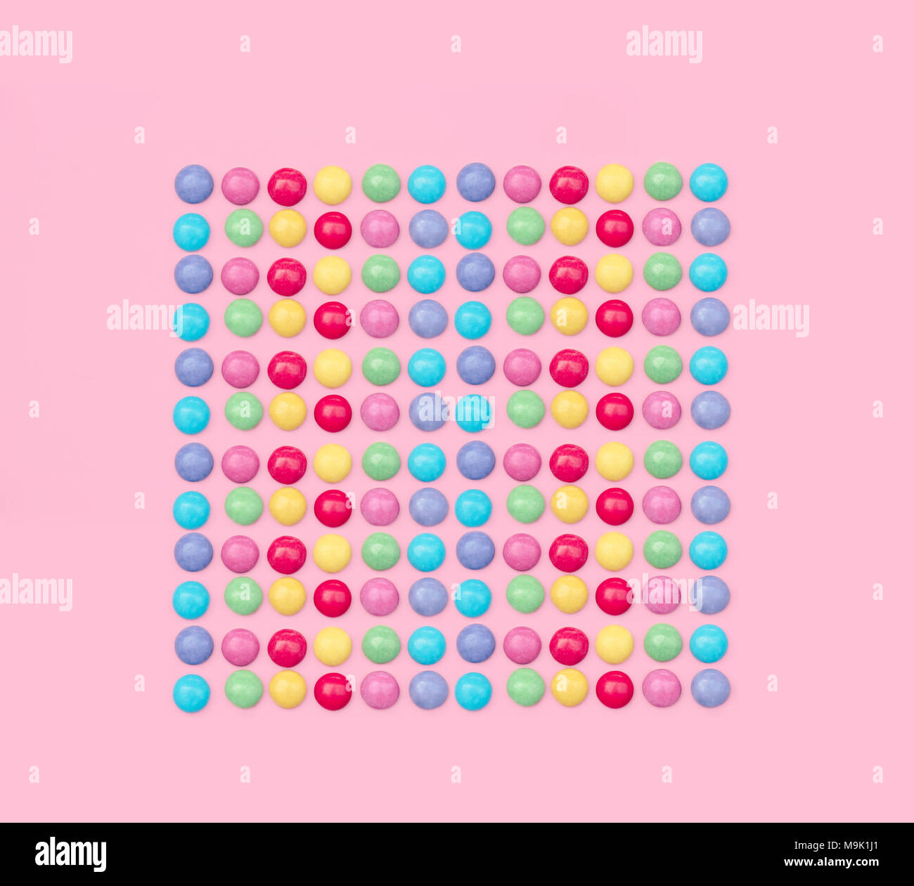 Assorted colored candies on pink background Stock Photo - Alamy