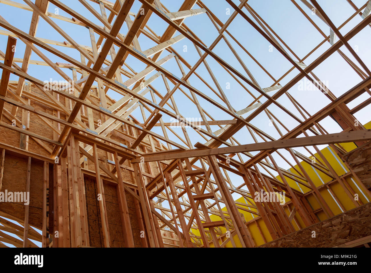 New construction home framing against blue sky, closeup of ceiling ...