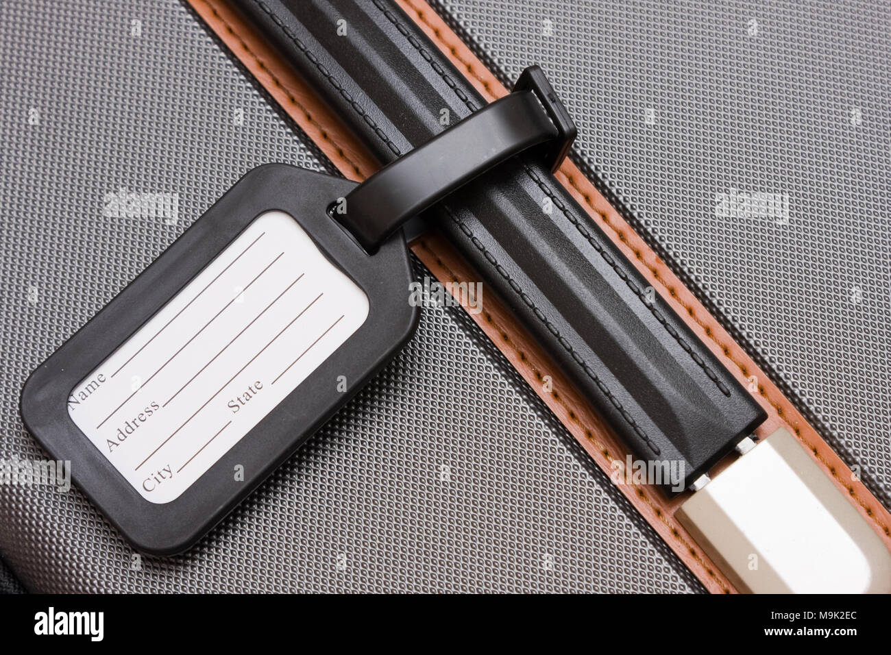 A black luggage tag on a handle on a bag Stock Photo - Alamy