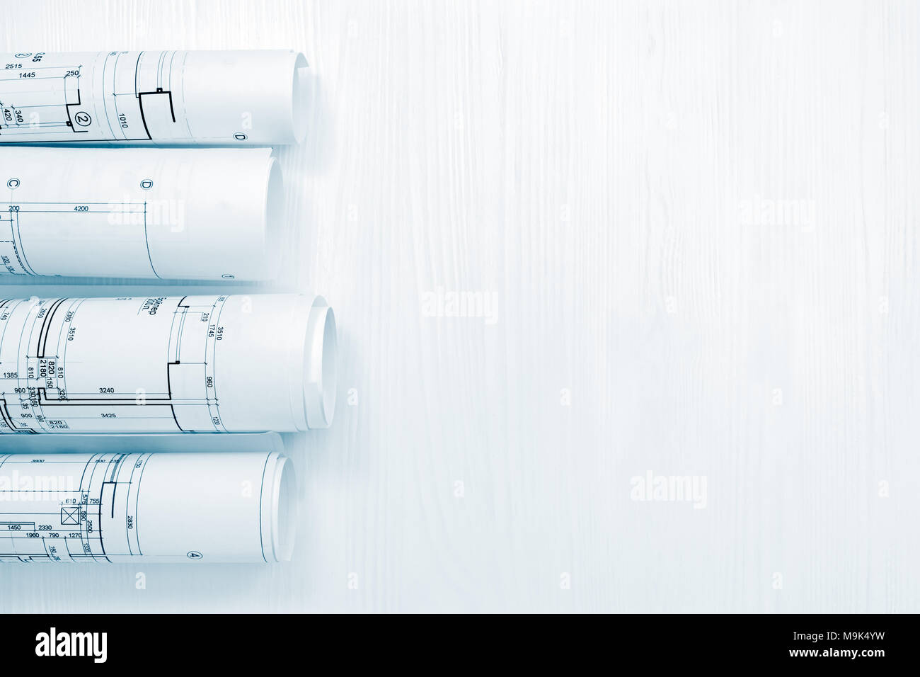 architectural background with blueprint rolls and technical drawings ...