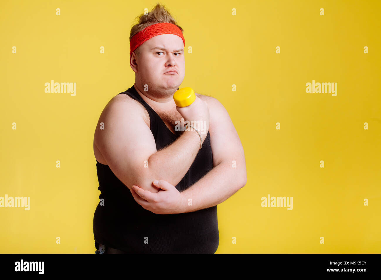 Fat man lifting dumbbell and show his biceps Stock Photo - Alamy