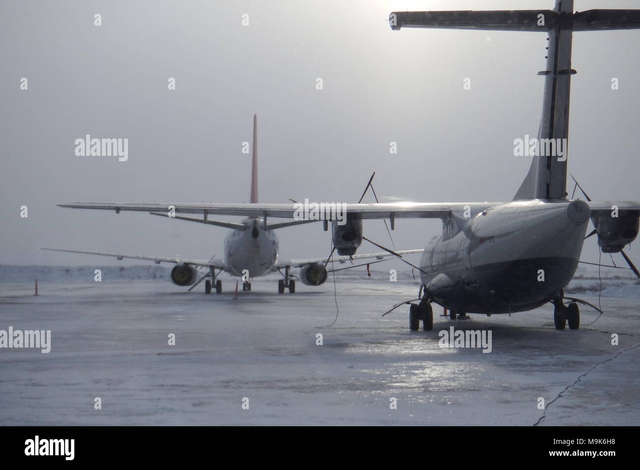 Planes queuing on an icy runway to take off Stock Photo - Alamy