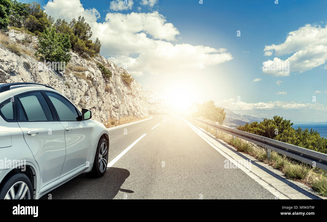 A white car rushing along a high-speed highway in the sun Stock Photo ...