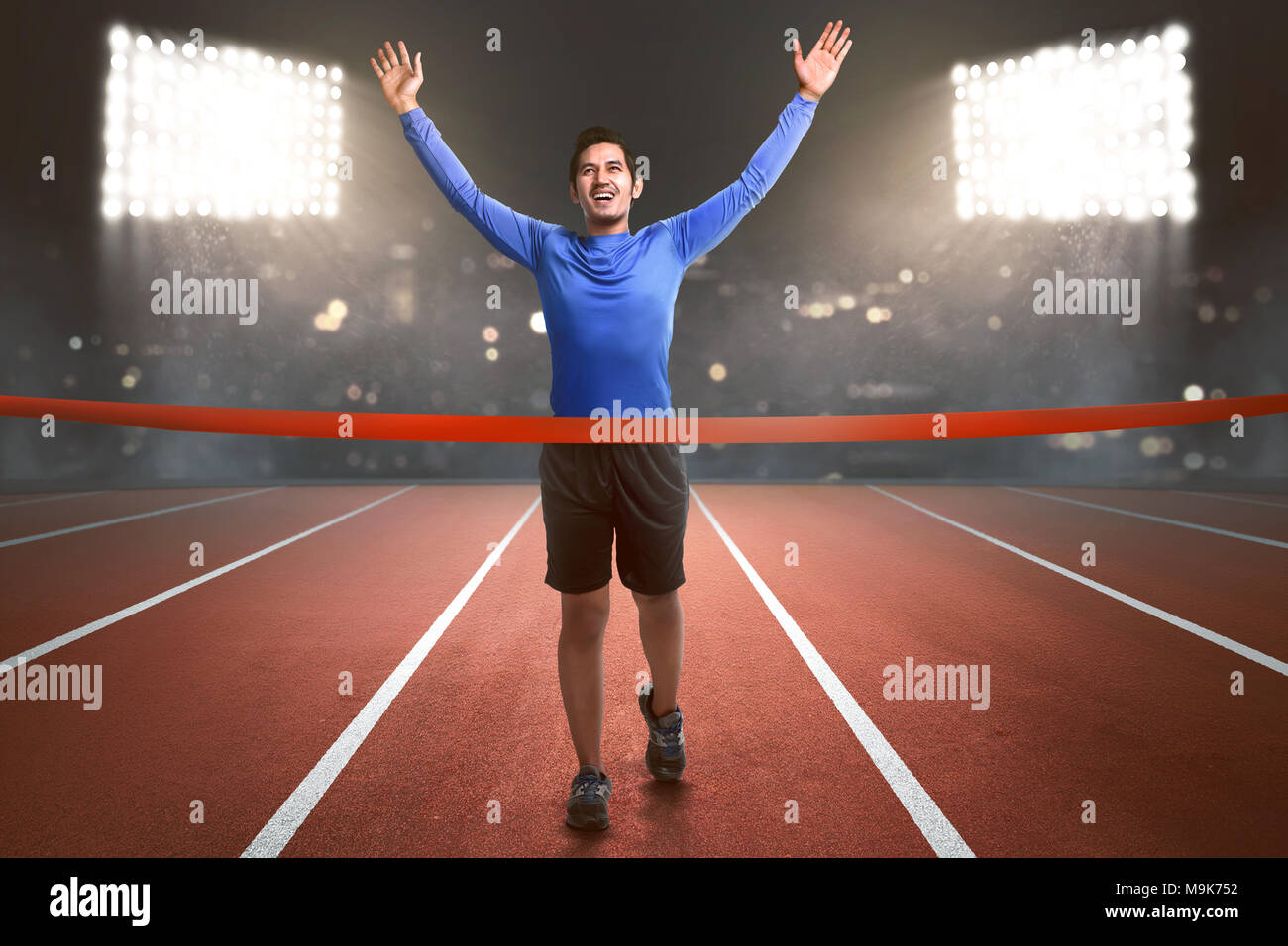 Happy asian athlete man running to finish line on the stadium Stock ...