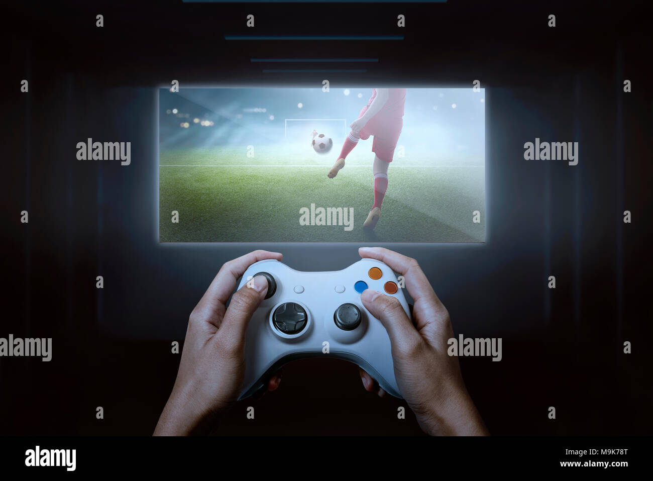 Hands with game controller playing football video game on tv Stock ...