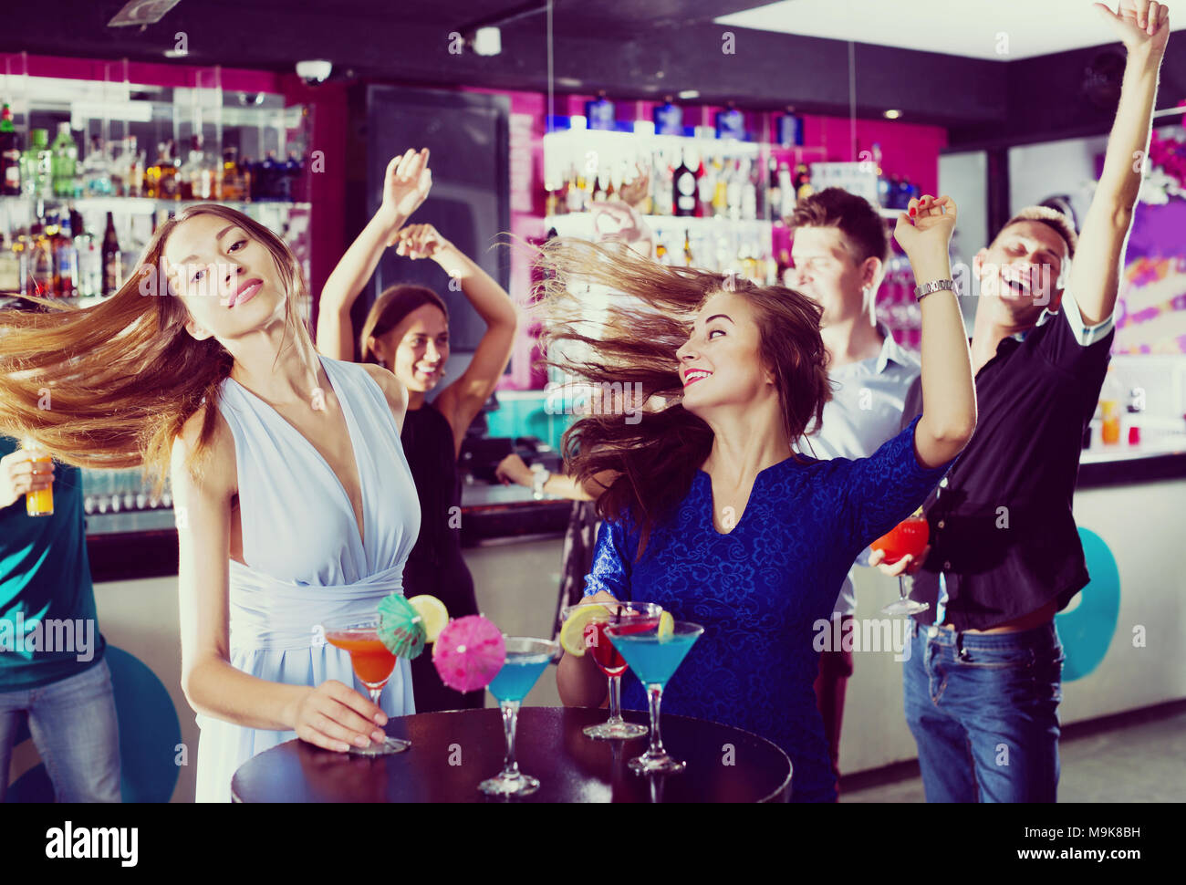 Two women are drinking cocktails on corporate party Stock Photo - Alamy