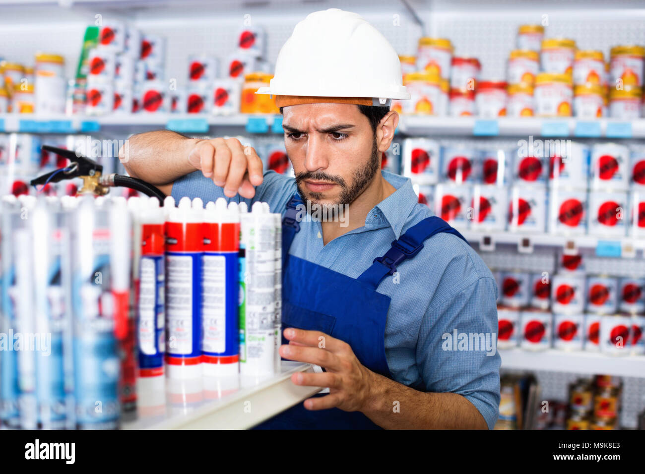 Focused positive smiling workman choosing materials for renovation ...