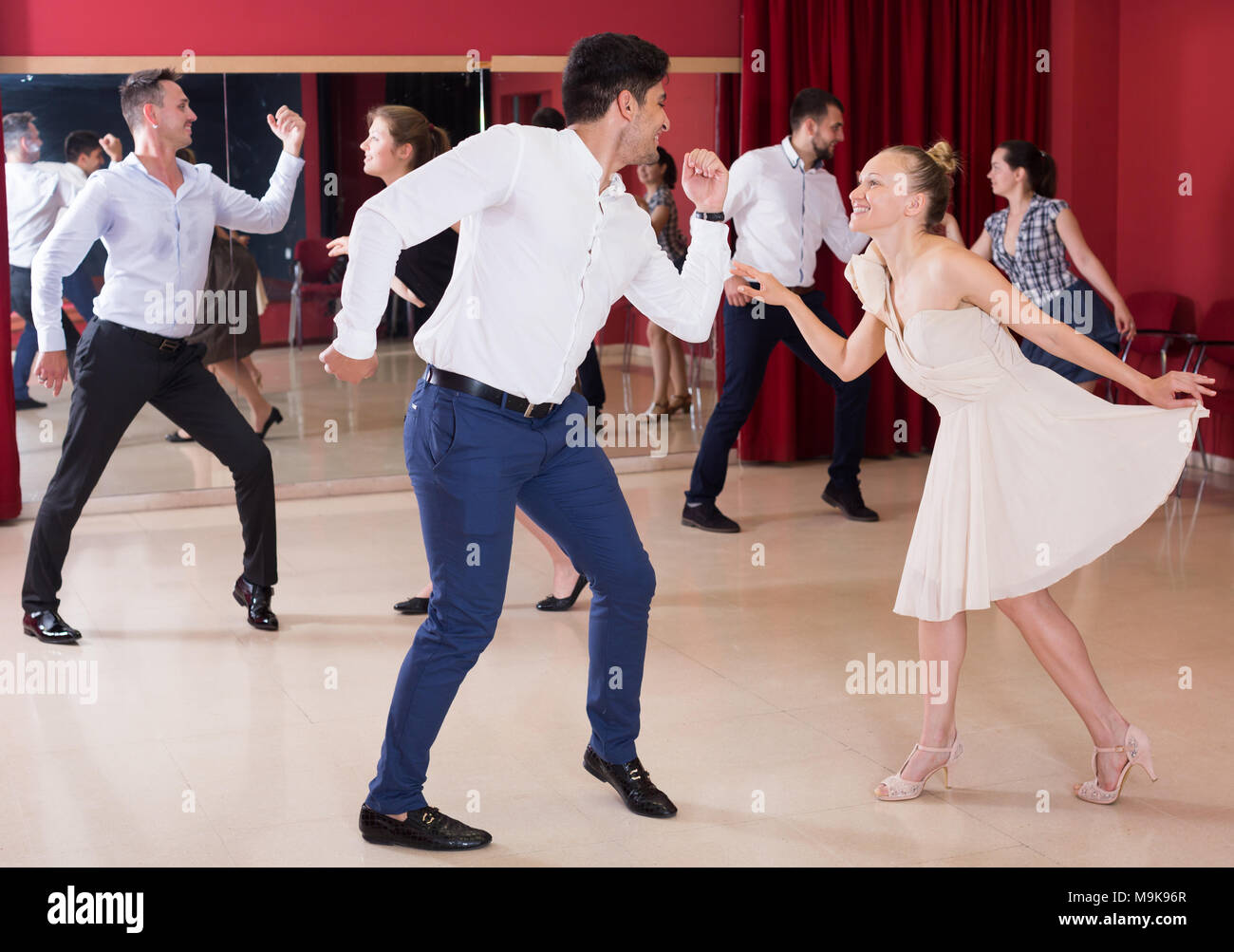 Adult dancing couples enjoying active dance in modern studio Stock ...
