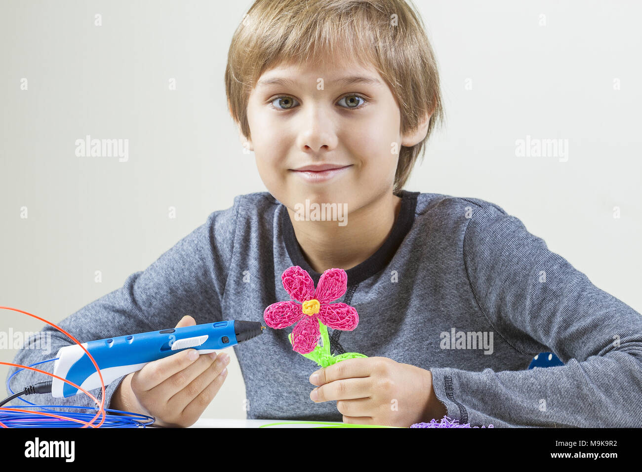 Happy boy creating with 3D pen Stock Photo - Alamy