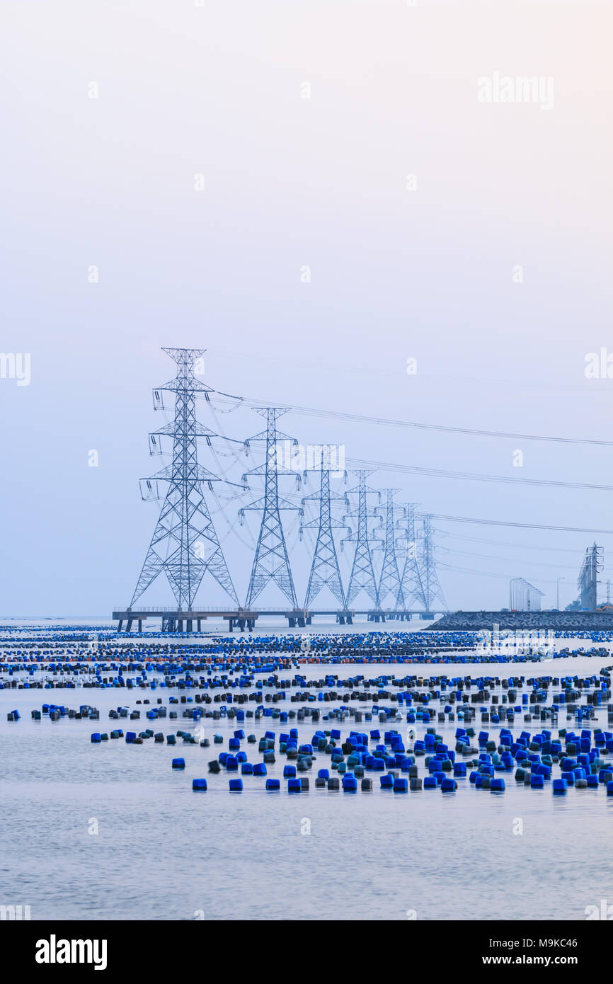 Row of high voltage poles and many tanks floating above the sea Stock ...