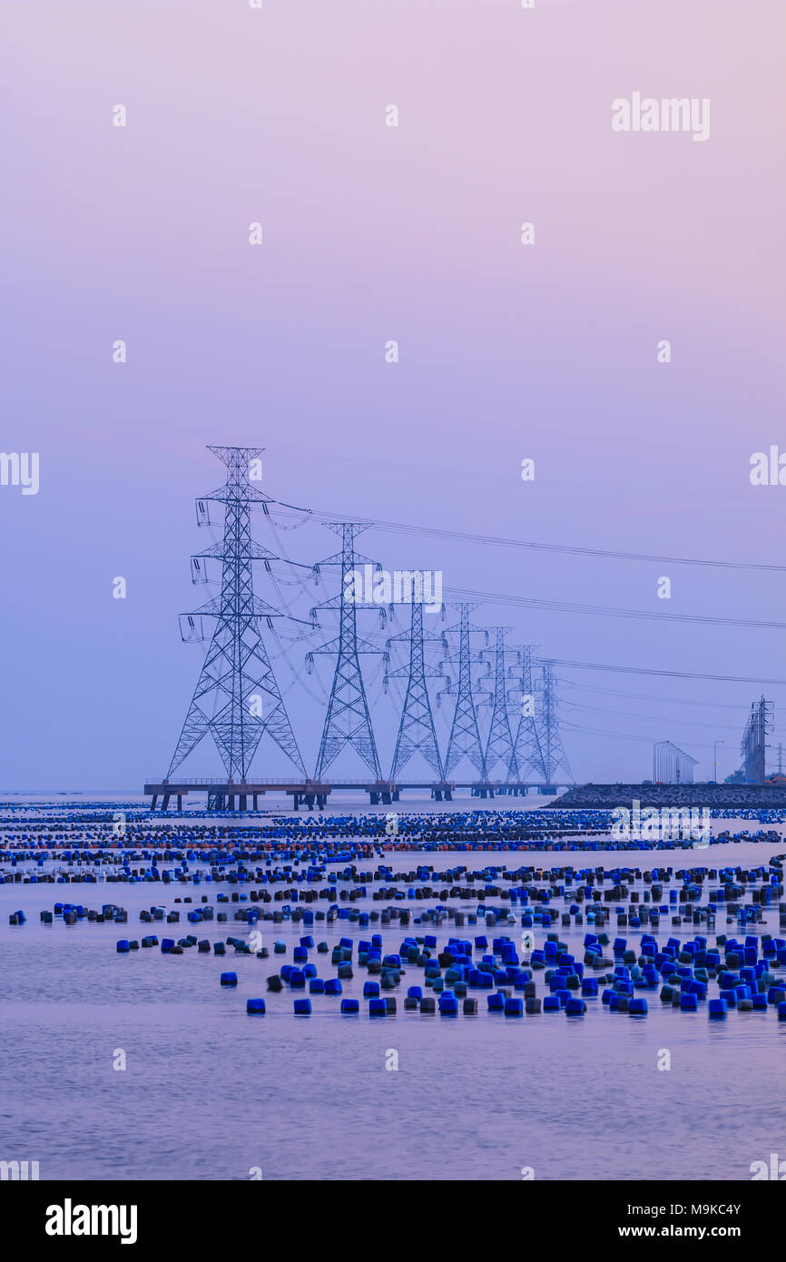 Row of high voltage poles and many tanks floating above the sea Stock ...
