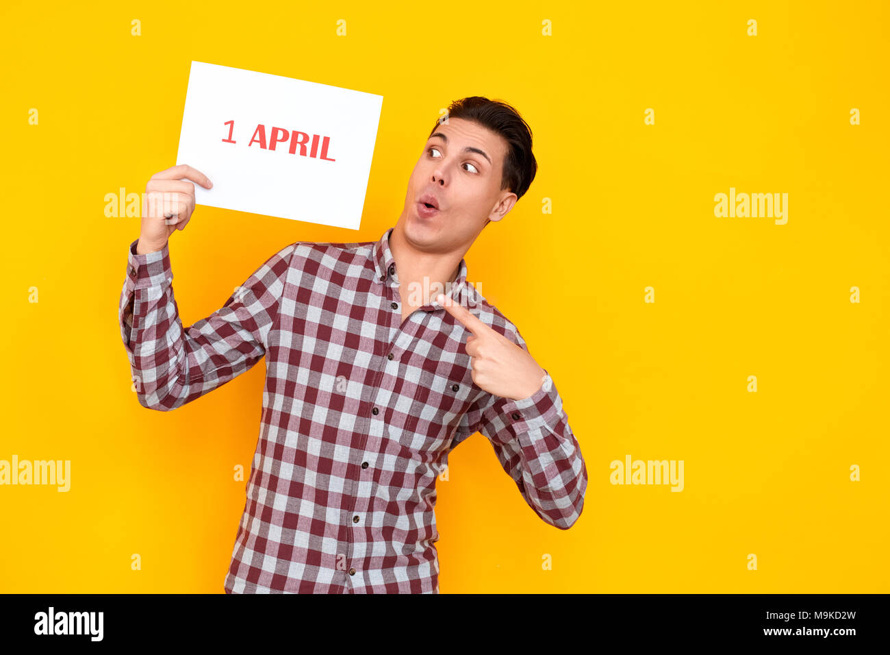 Man pointing finger at table with an inscription 1 april. Fool's day ...