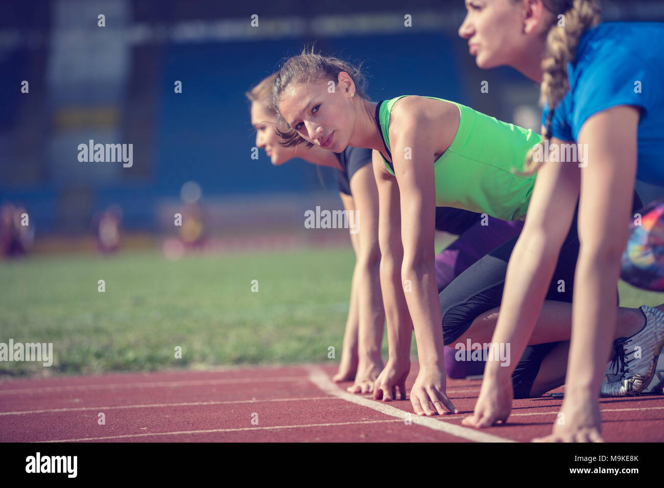 Women ready to race on track field Stock Photo - Alamy