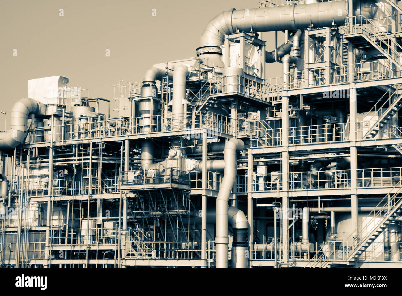 A part of a chemical plant with a complex structure of tanks, pipes and ...
