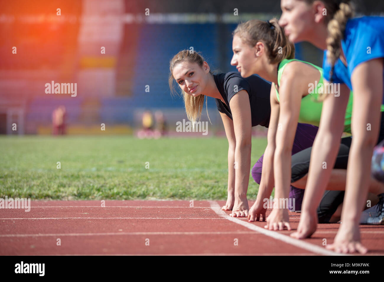 Women ready to race on track field Stock Photo - Alamy