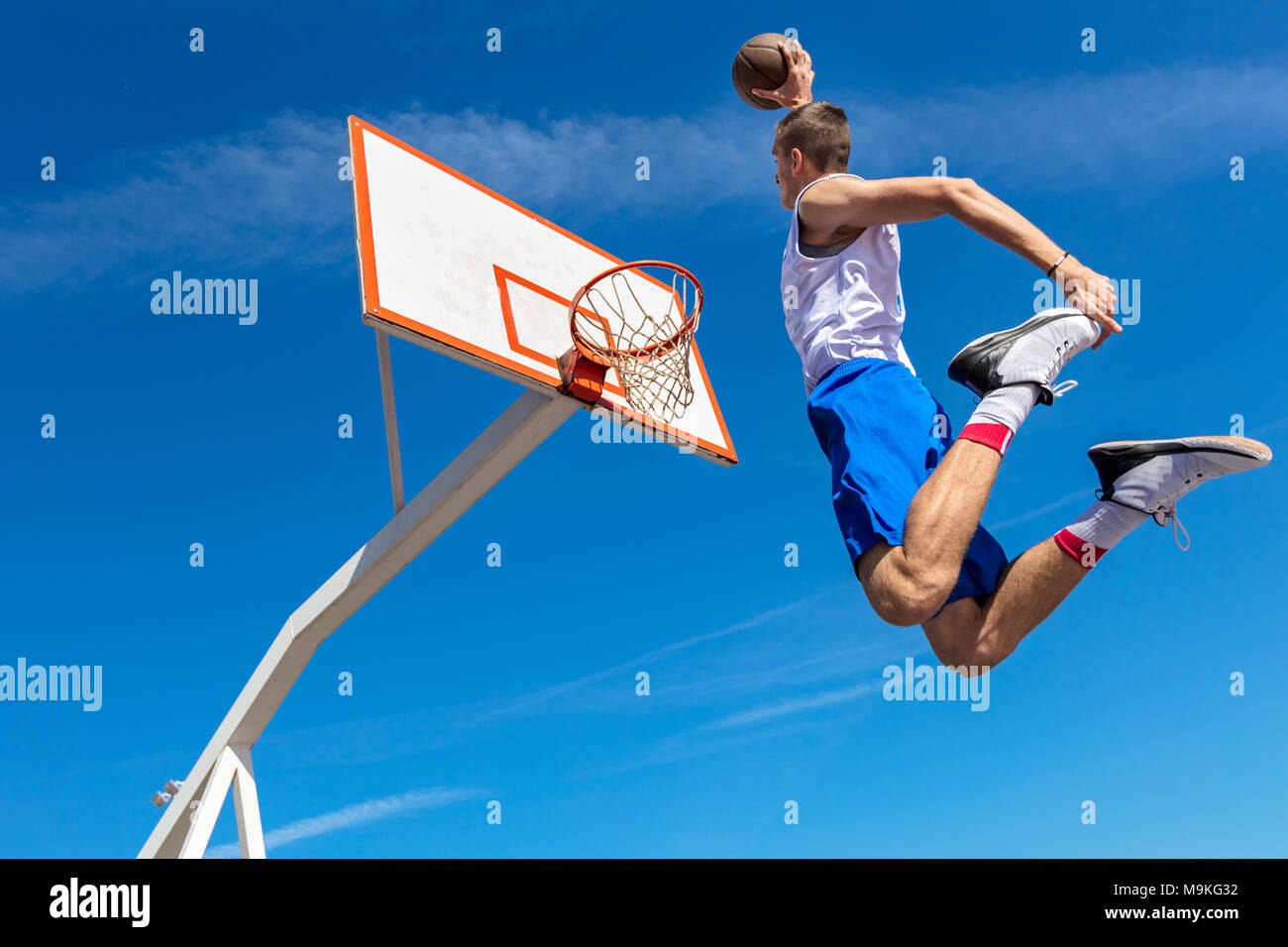 Young Basketball street player making slam dunk Stock Photo - Alamy