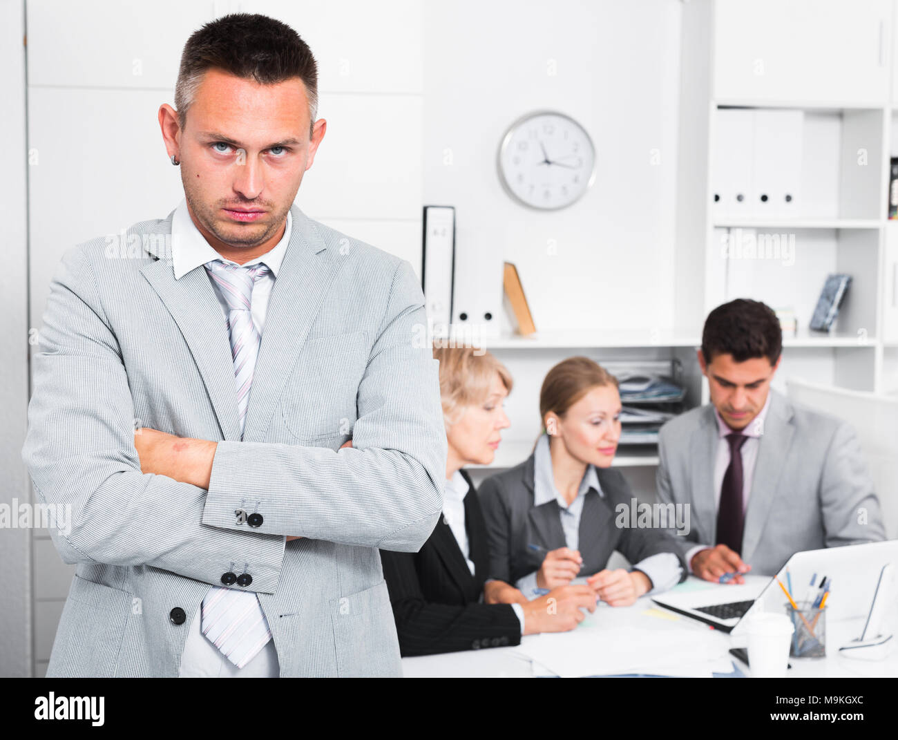 Business team tensely solving problems in office with upset man ...