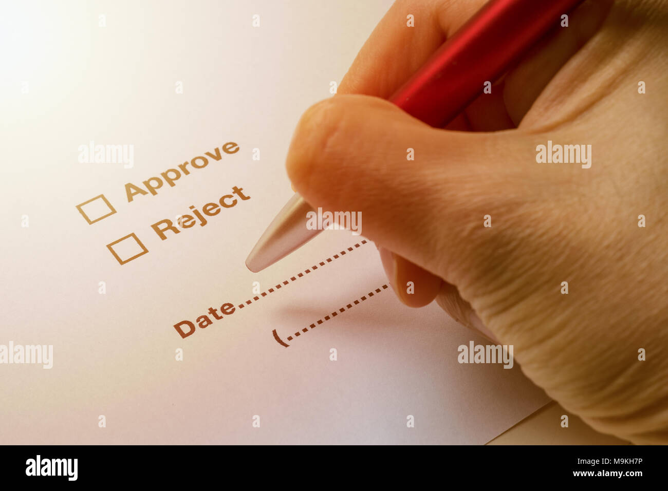 Business concept illustrated by hand holding pen to sign on approve or ...