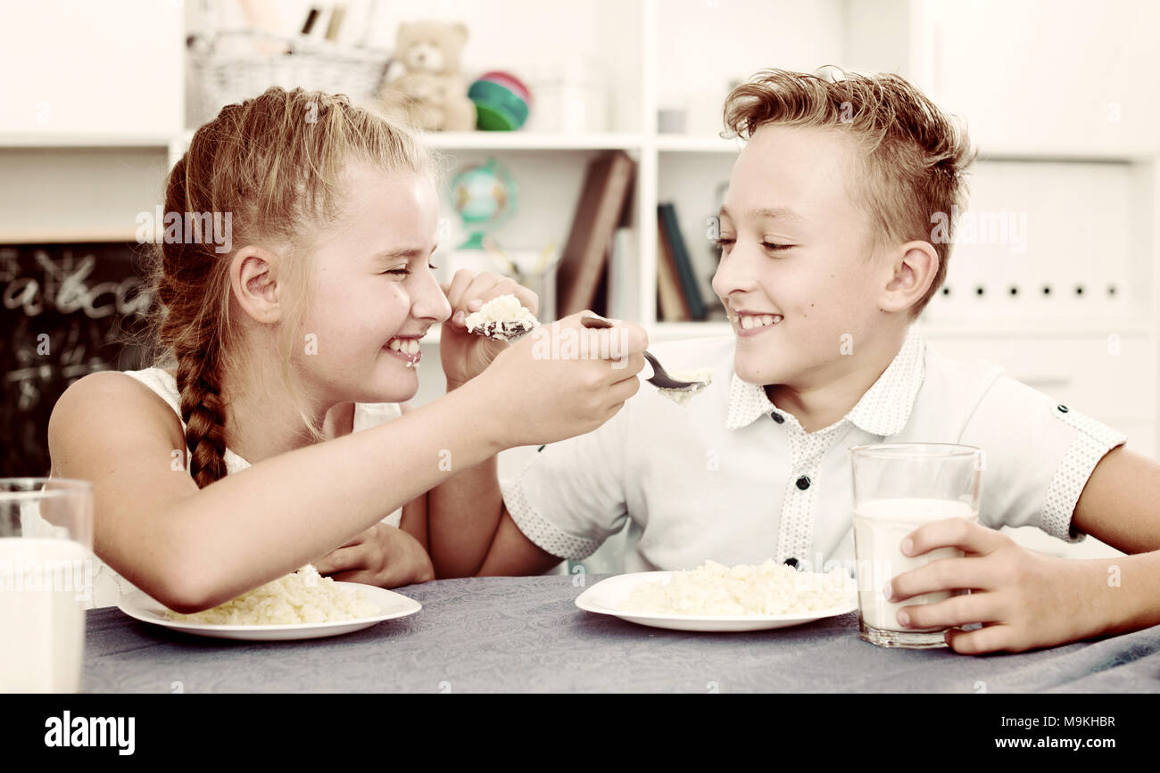 Sister with brother are playing with food at time lunch at home Stock ...