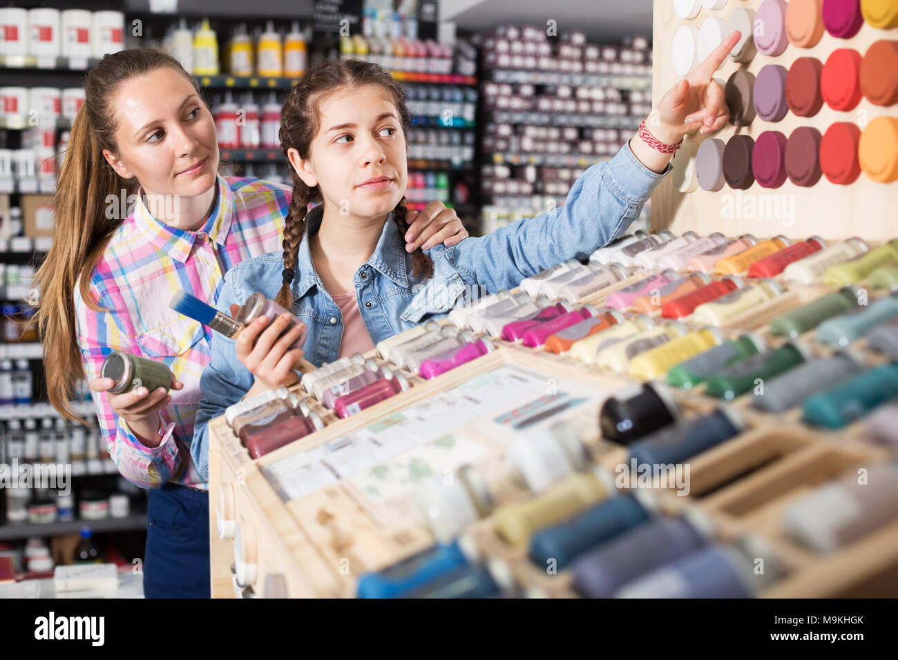 Cheerful woman and girl shopping color in glass jar in art shop Stock ...