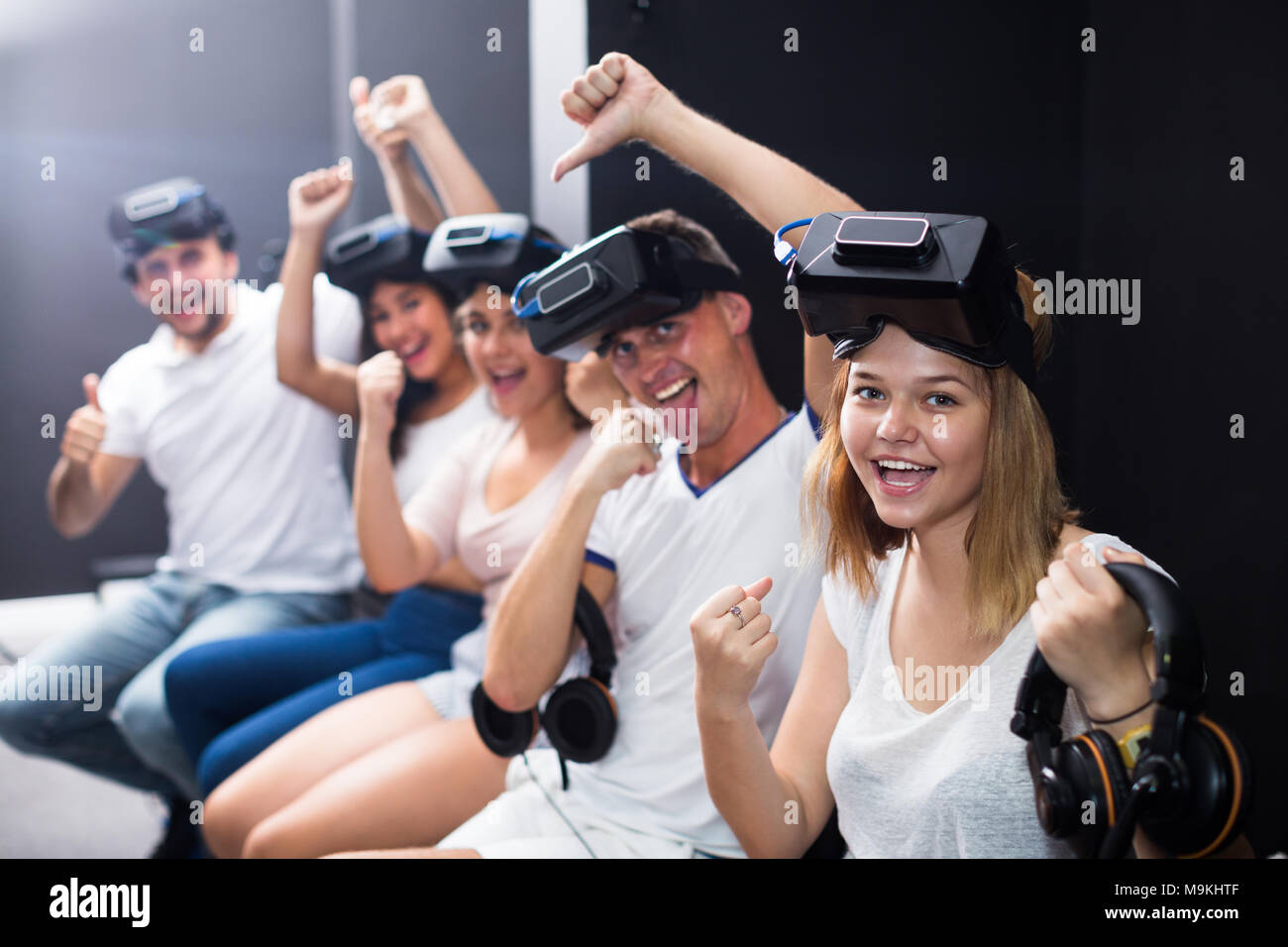 Group of cheerful friends are wearing virtual reality goggles and ...