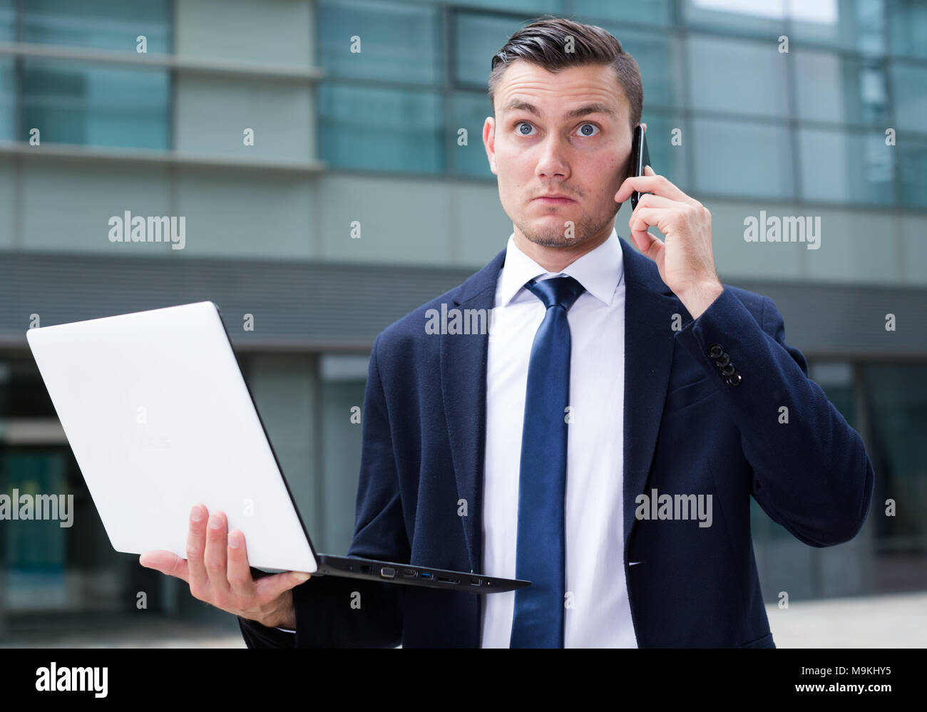 Creative director is standing with laptop near the office and ...