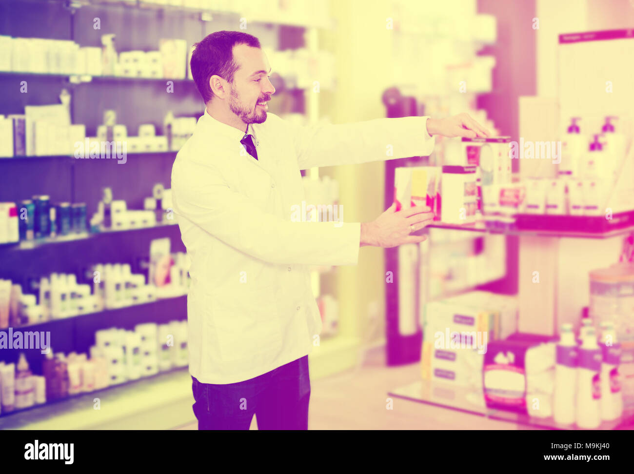 Young male pharmacist searching for reliable drug in pharmacy Stock ...