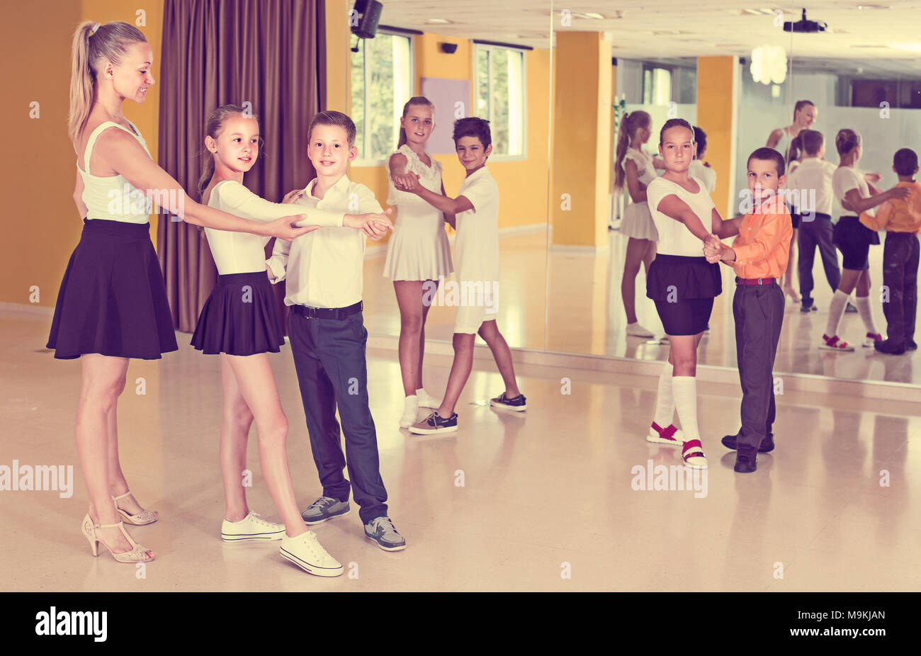 Teacher is demonstrating to children how to dance waltz in class Stock ...