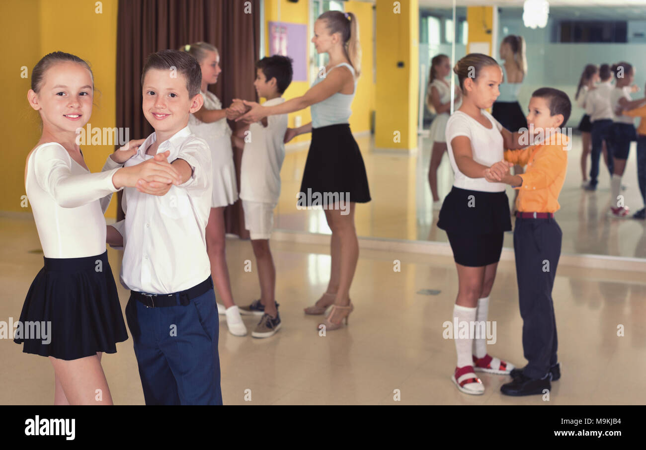 Group of friendly smiling children dancing tango in dance studio Stock ...