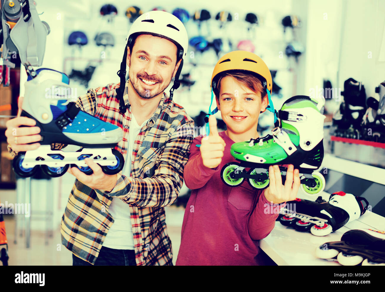 Happy positive father and son showing roller-skates they bought in ...