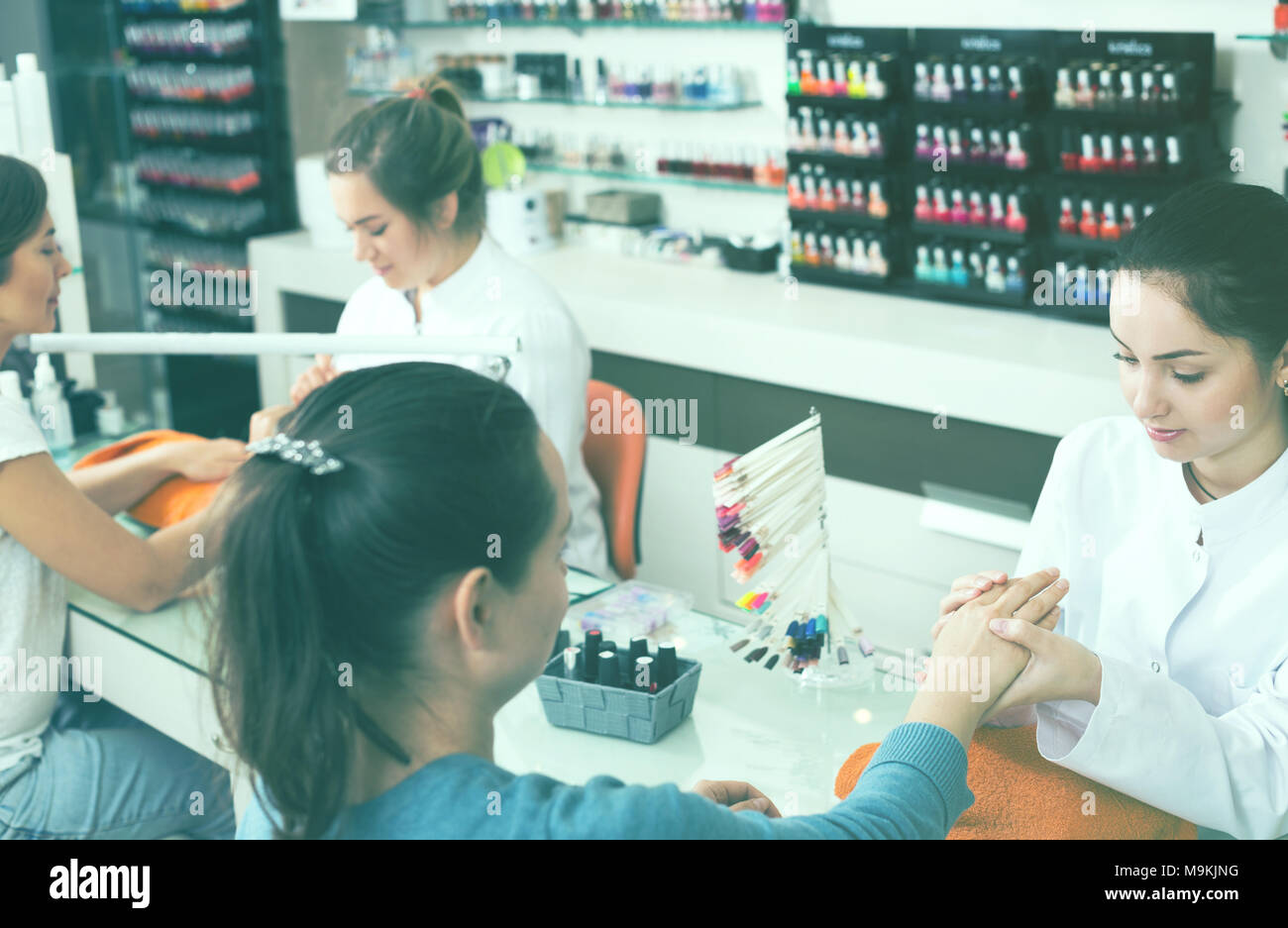 Nail technicians performing manicure procedure in beauty salon Stock ...