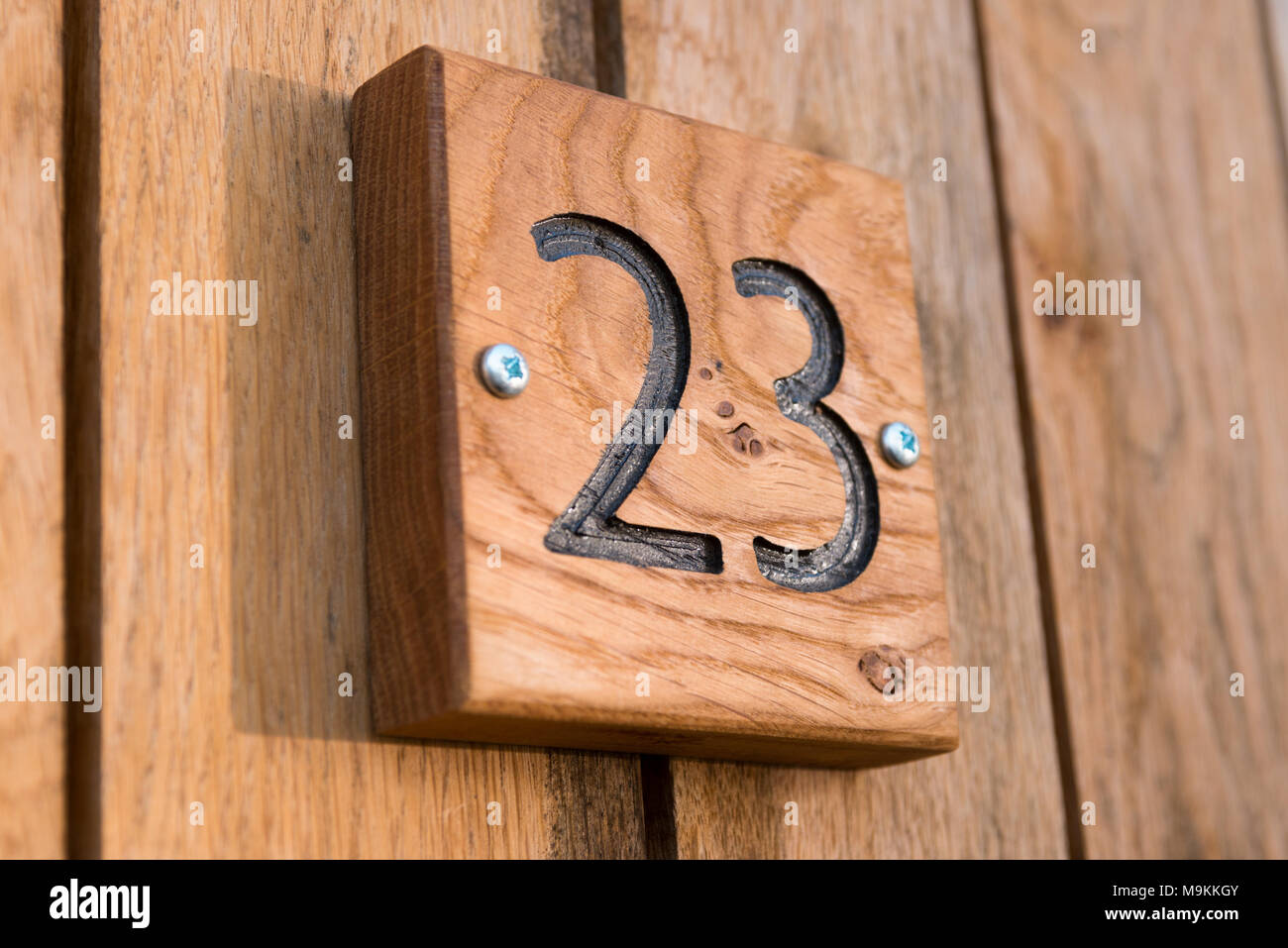 The number twenty three carved into a wood tile plaque on a home to ...