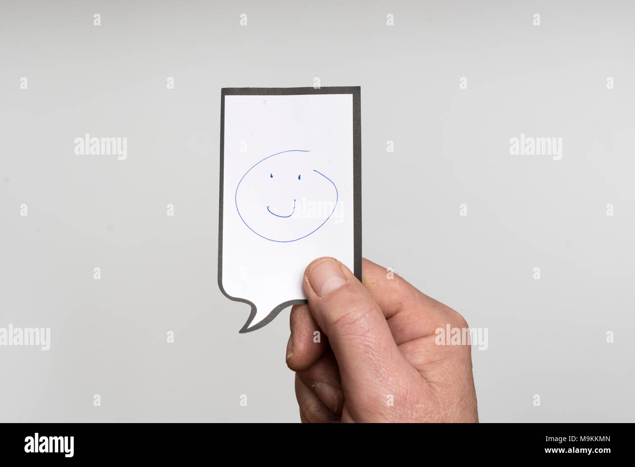 a small piece of paper with a drawing of a smiling face Stock Photo - Alamy
