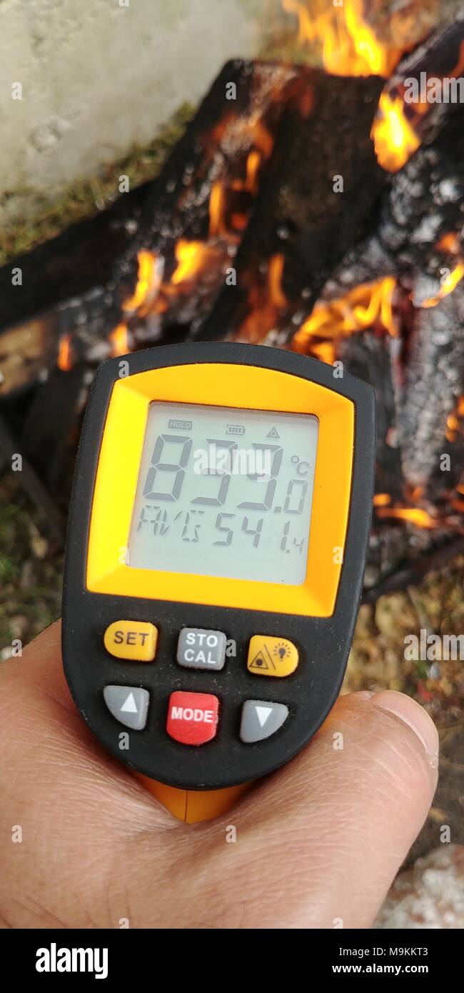 Handheld laser remote thermometer measures the temperature of a fire ...